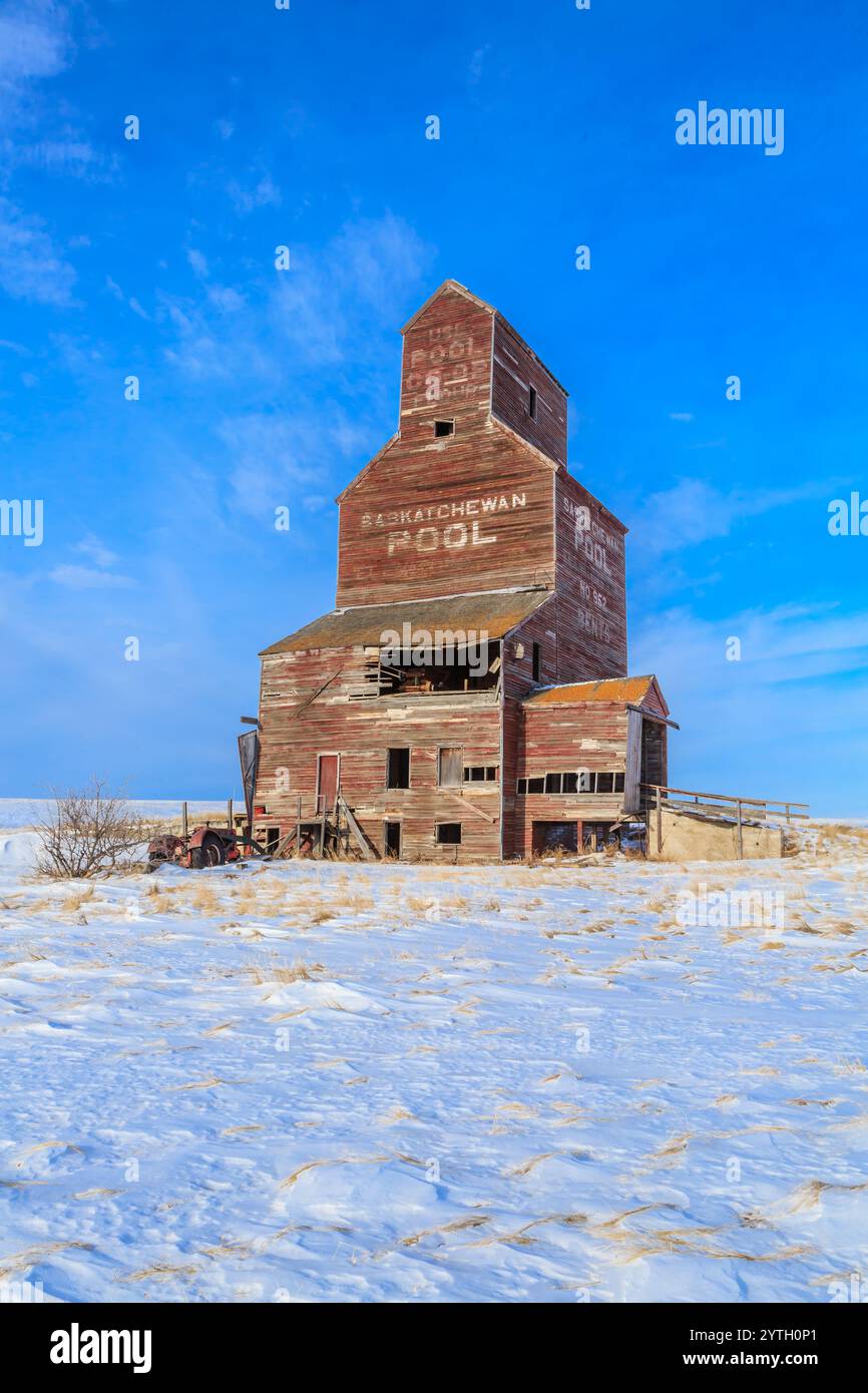 A large, old, abandoned grain silo with a sign on it. The silo is ...