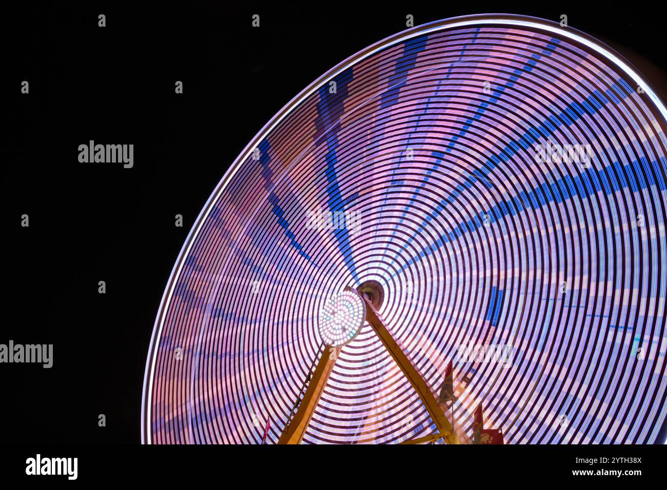 A colorful merry go round with a blue and white stripe. The colors are ...