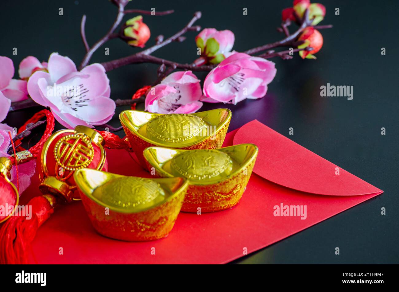 Golden Ingots on top of Chinese New Year red packet. Chinese New Year ...