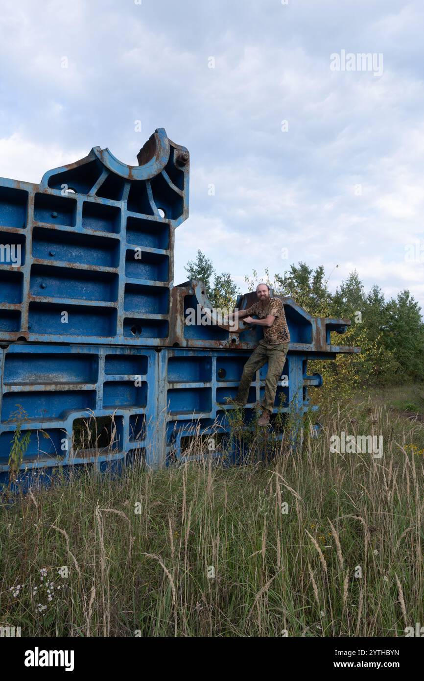 Urban Exploration: Man Posing with Abandoned Blue Industrial Structure ...