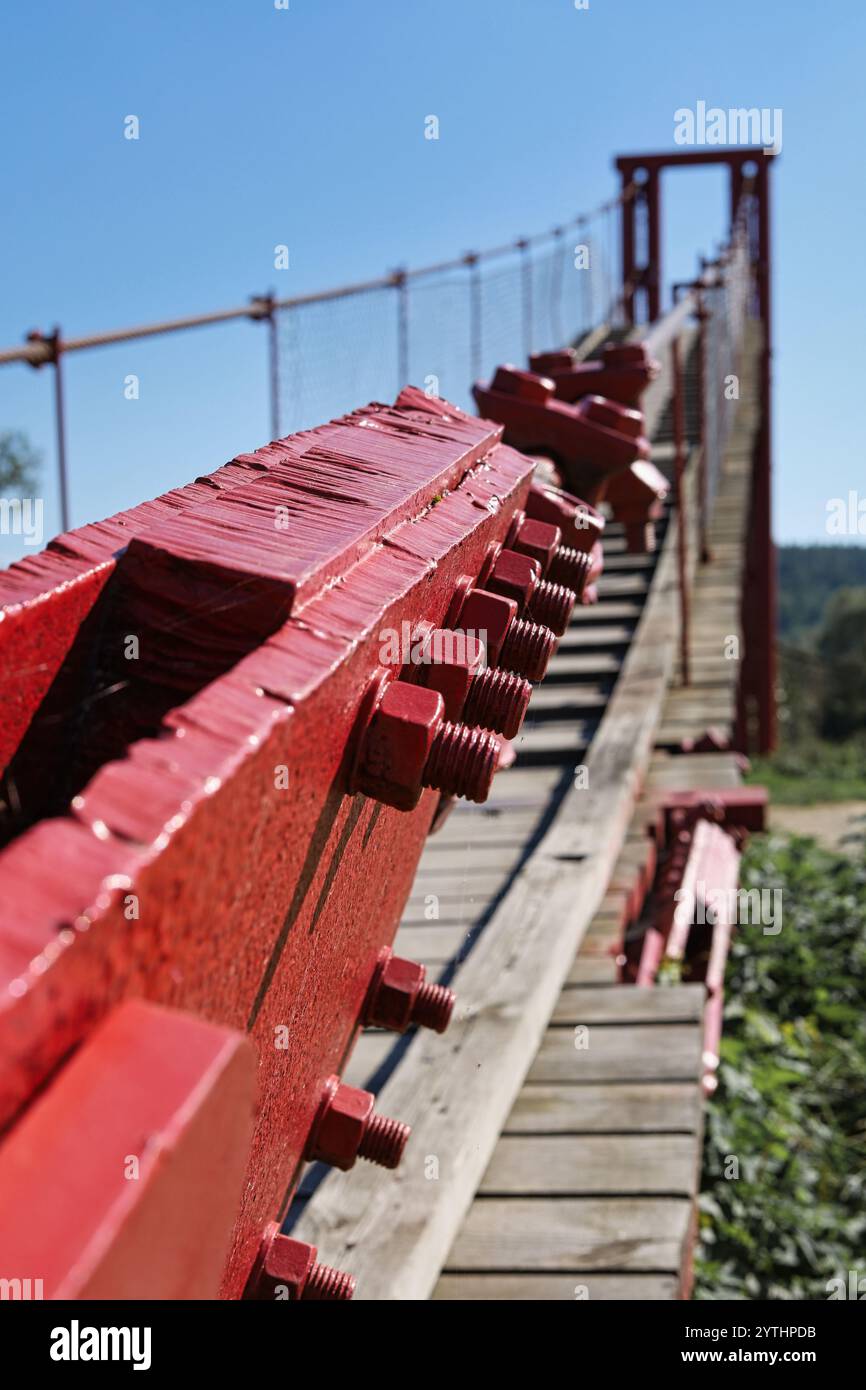A screw anchor securing a steel cable supporting a pedestrian bridge ...