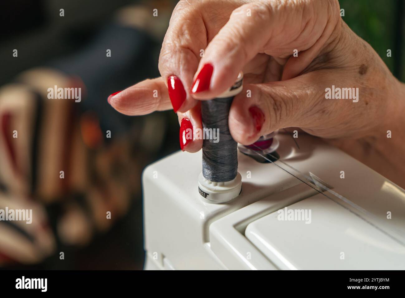Seamstress preparing the spool of thread to start sewing Stock Photo ...