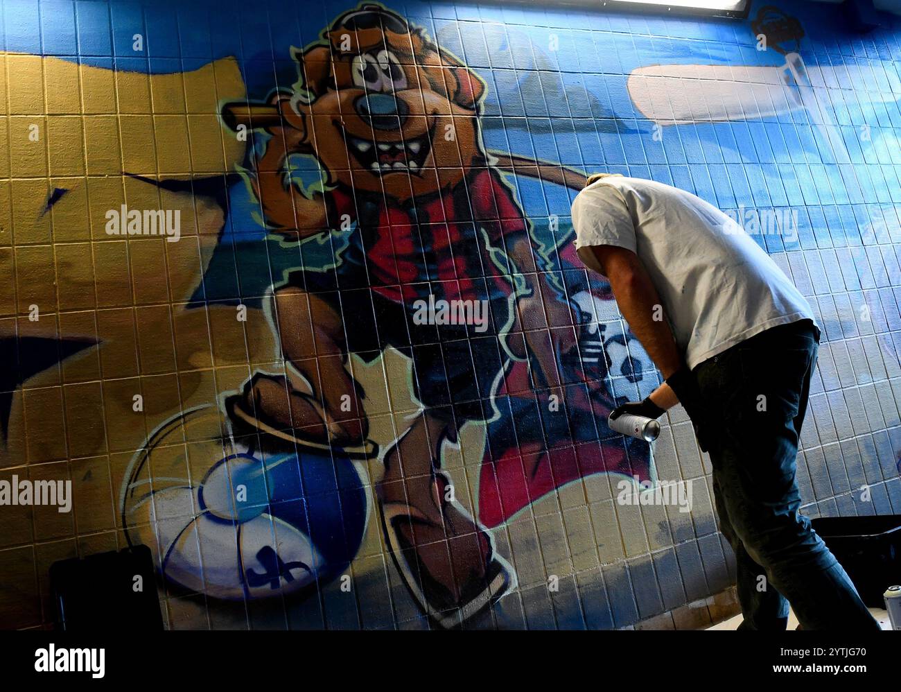 A graffiti artist is seen working on an image of AFC Bournemouths ...