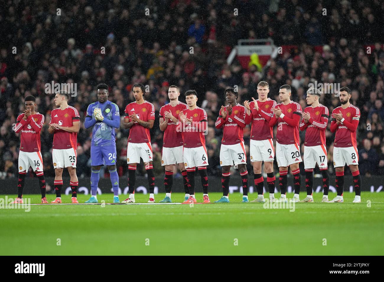 Manchester United players stand for a minutes applause in memory of ...