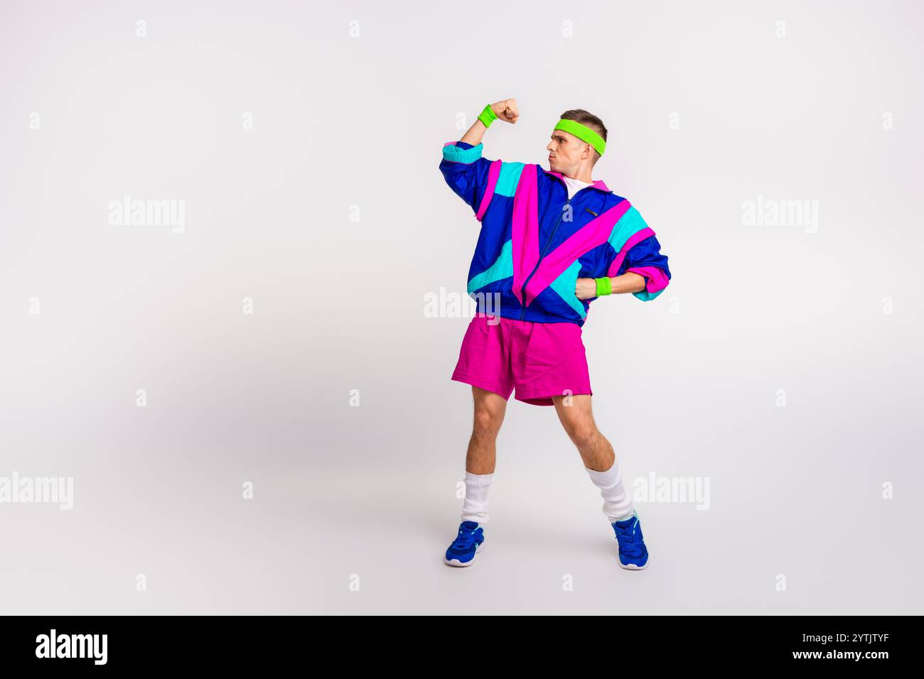 Energetic young man in vibrant retro sportswear against a white ...