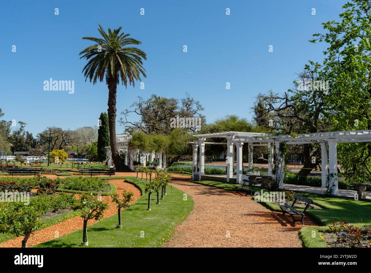 A Brick or clay path in a botanical garden with a white gazebo Stock ...