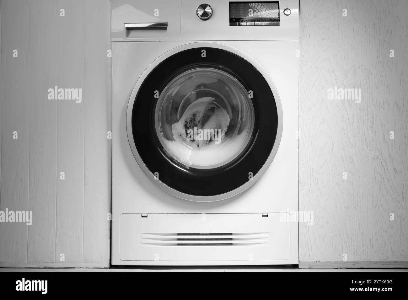 White washing machine with suds in bathroom Stock Photo - Alamy