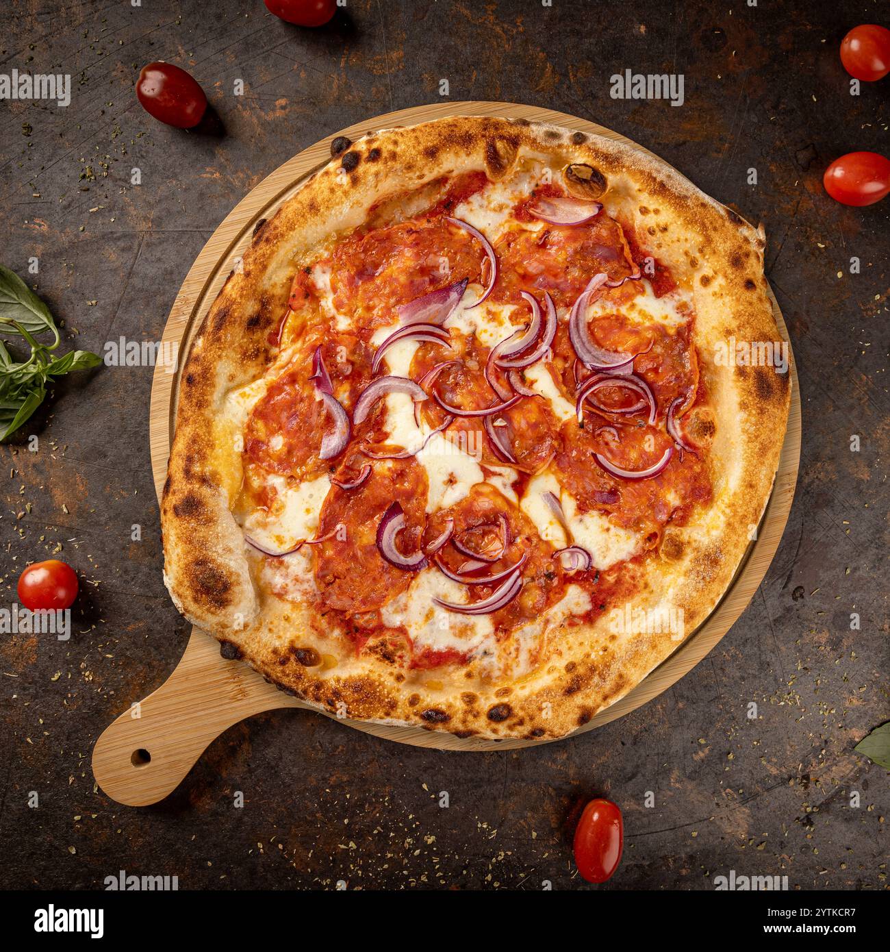 Round pizza with pepperoni, red onions and mozzarella cheese, garnished ...