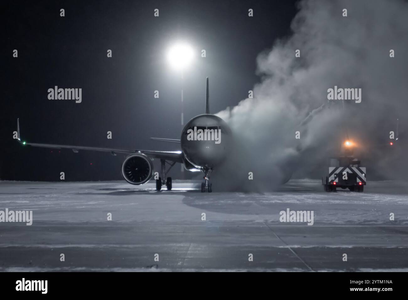 Ground deicing of a passenger plane on the night airport at winter ...