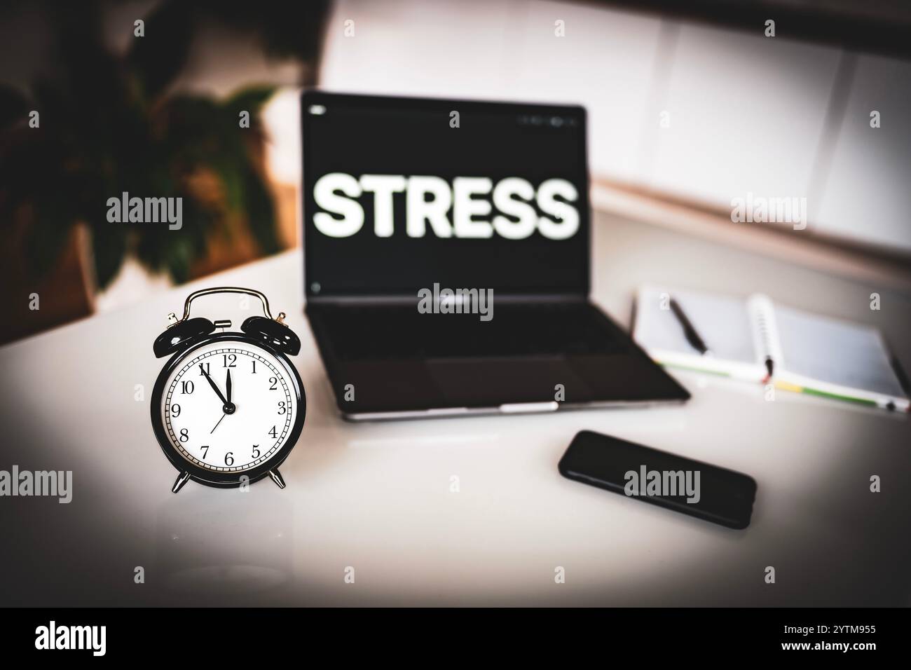 Word stress on the laptop screen, notes and a clock on a office desk ...