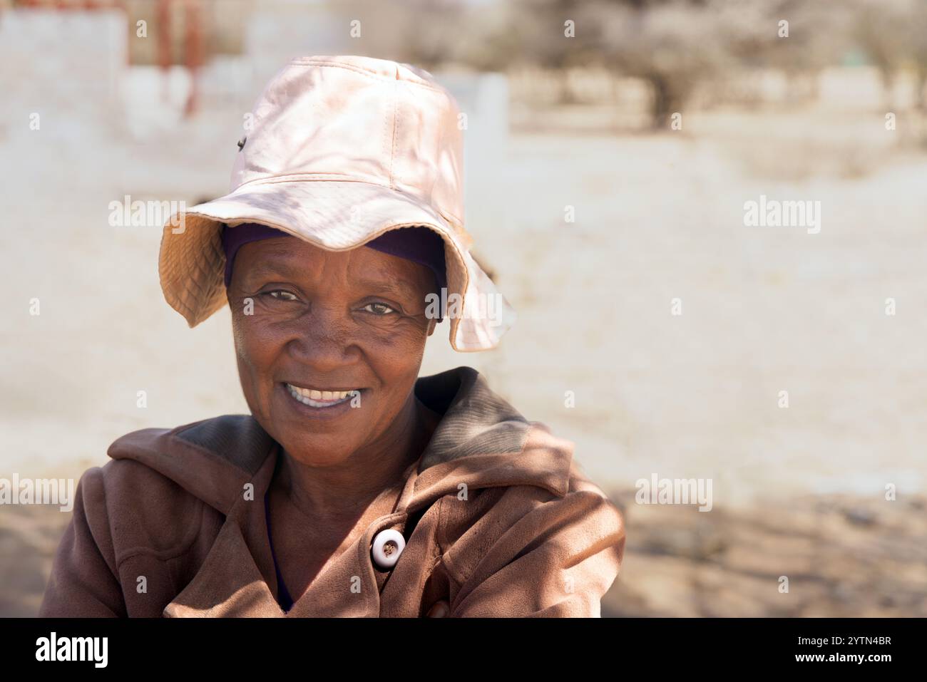 african village, single woman with hat and a big toothy smile standing ...