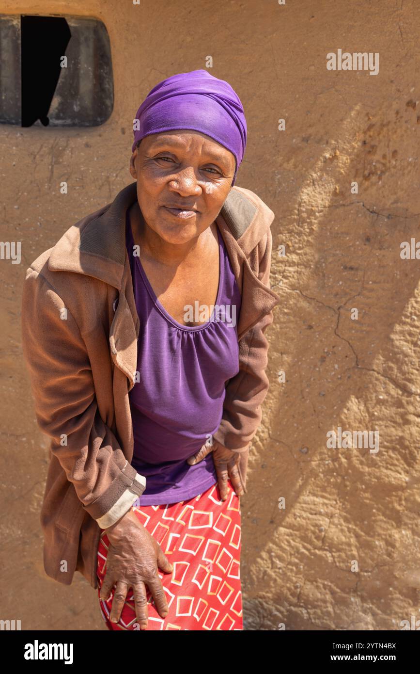 african village, single woman with headgear standing in the yard ,in ...