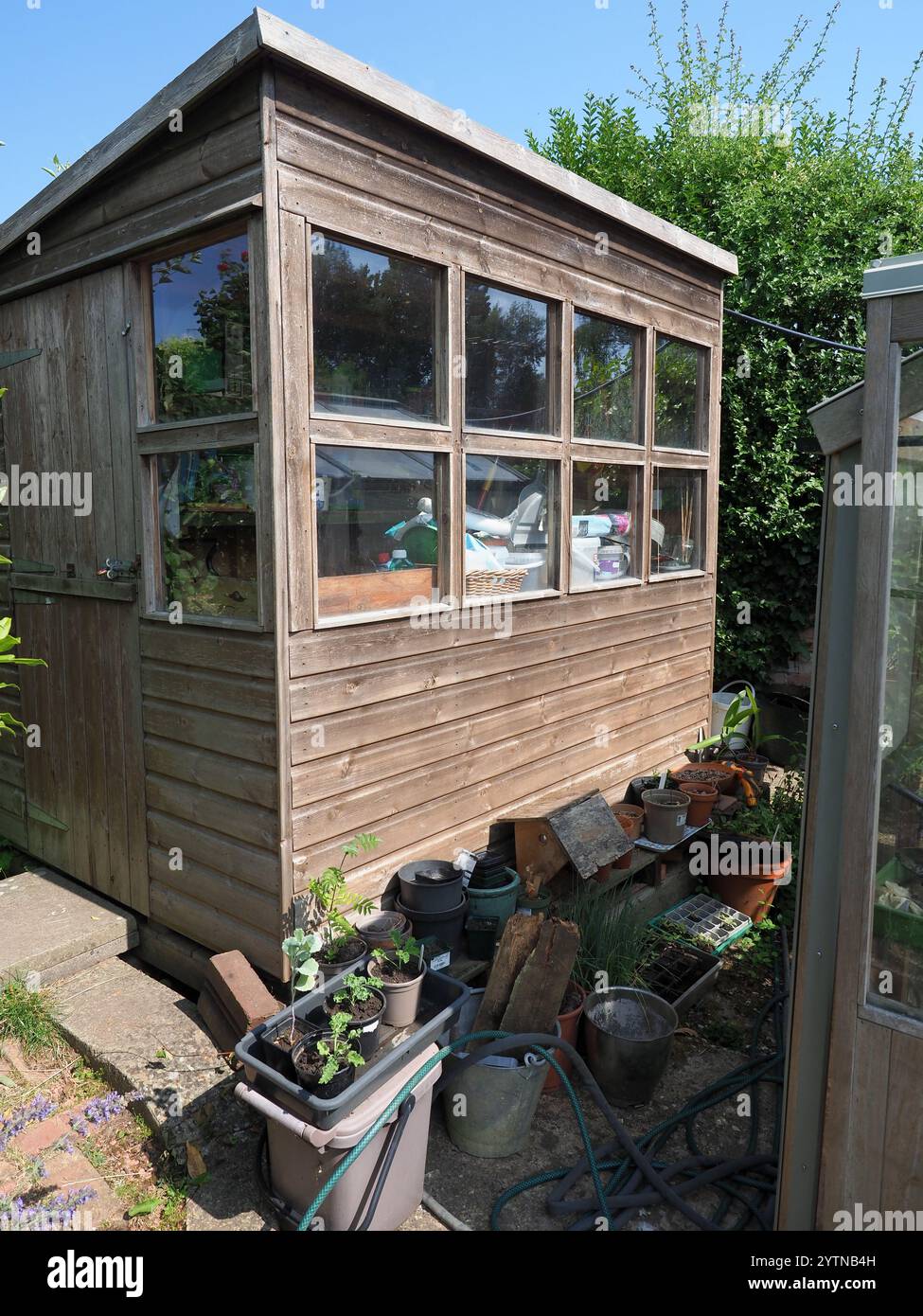 a large wooden garden shed with windows in one side Stock Photo - Alamy