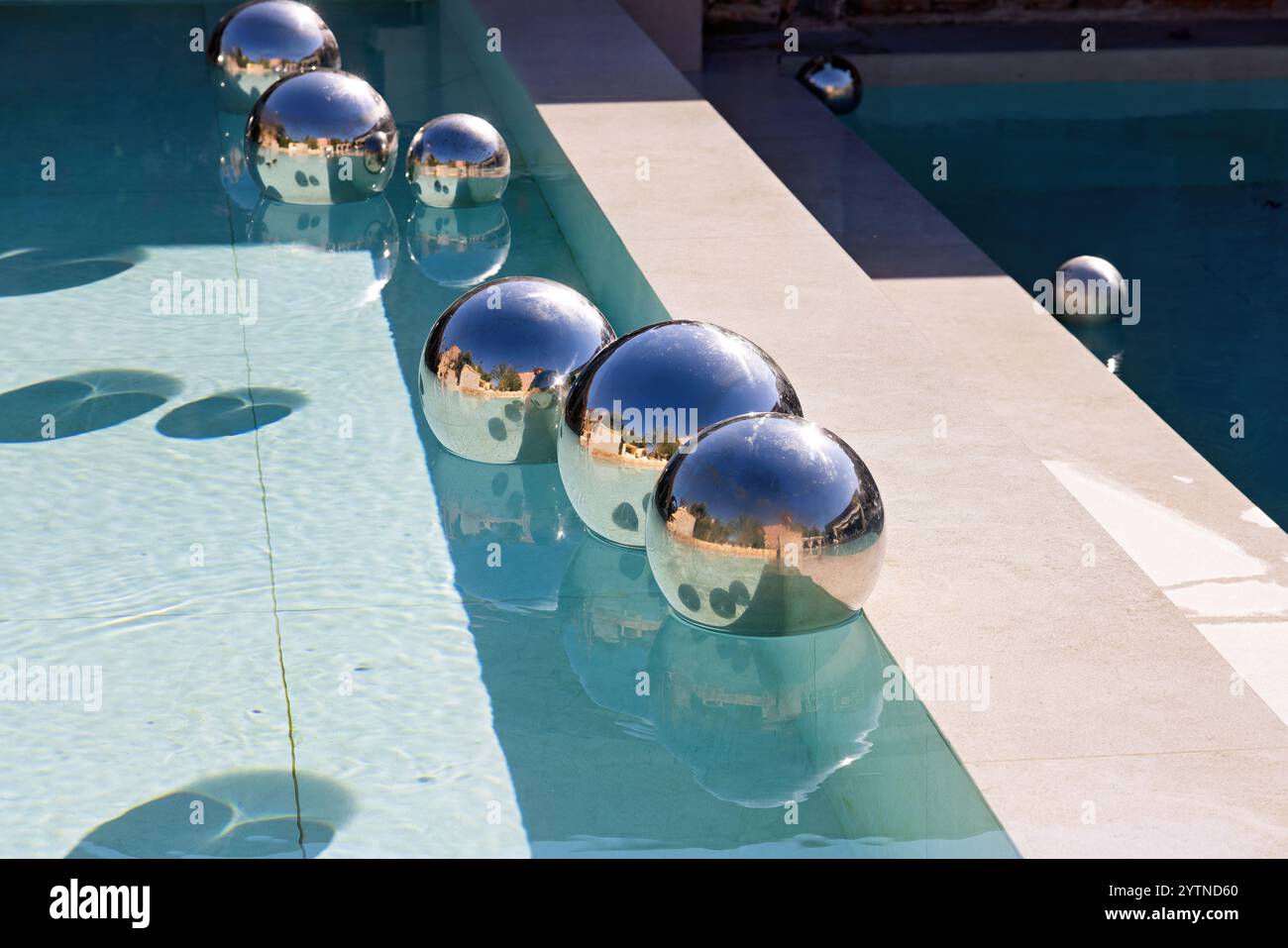 silver balls in the swimming pool that reflect sunlight and ...
