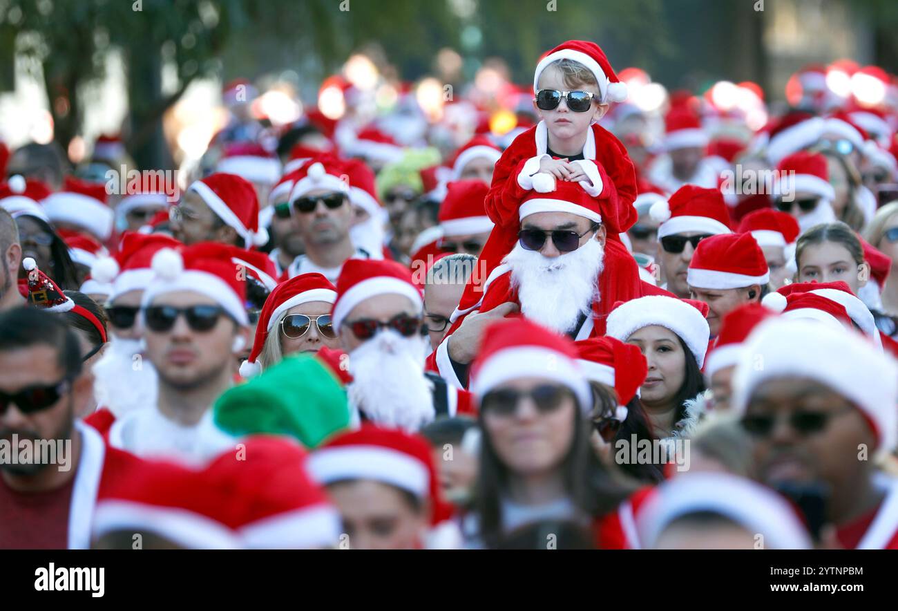 A boy gets a lift to the start line during the Las Vegas Great Santa ...