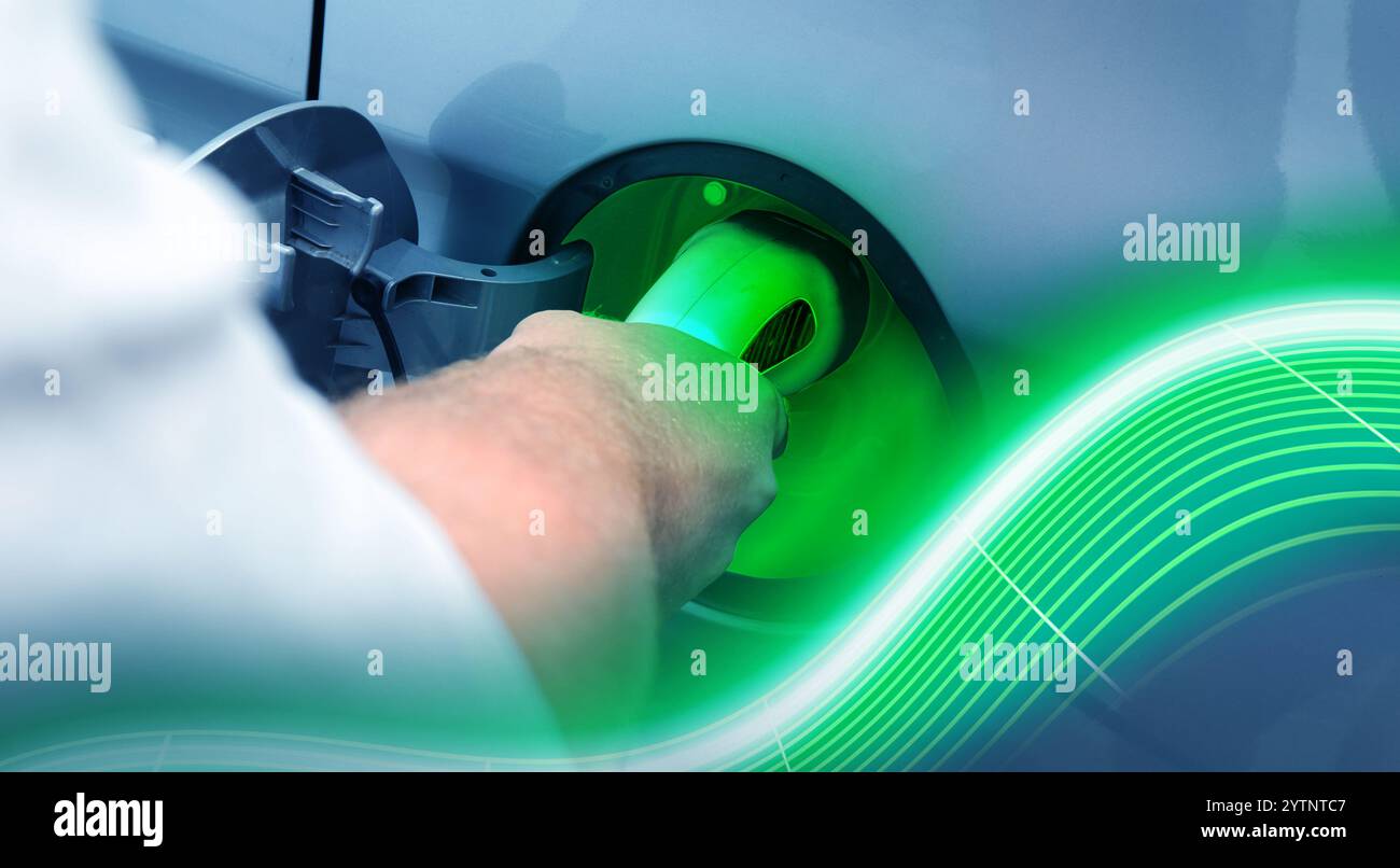 Man inserting plug into electric car socket at charging station ...