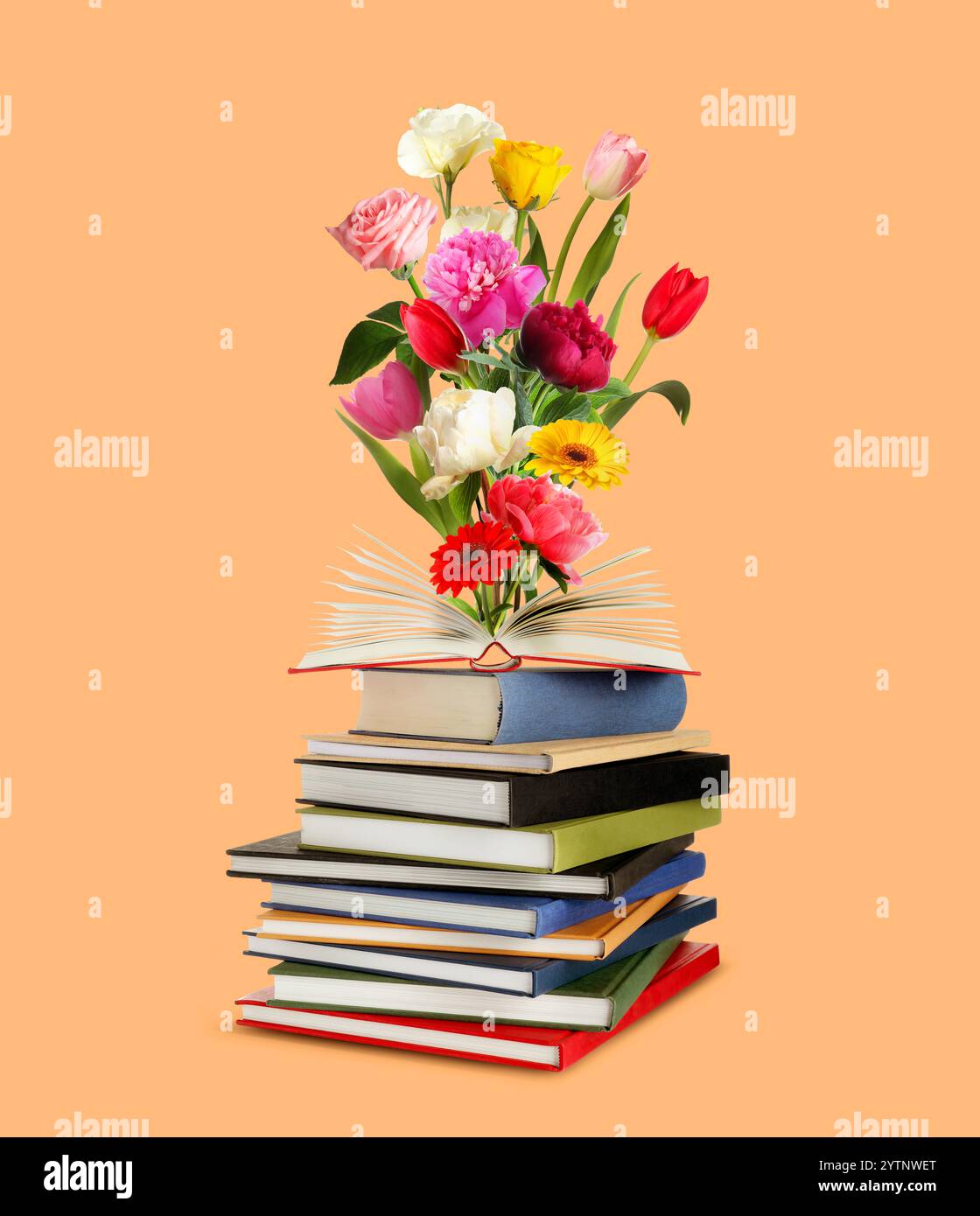 Stacked books and open one with beautiful flowers between pages on pale ...