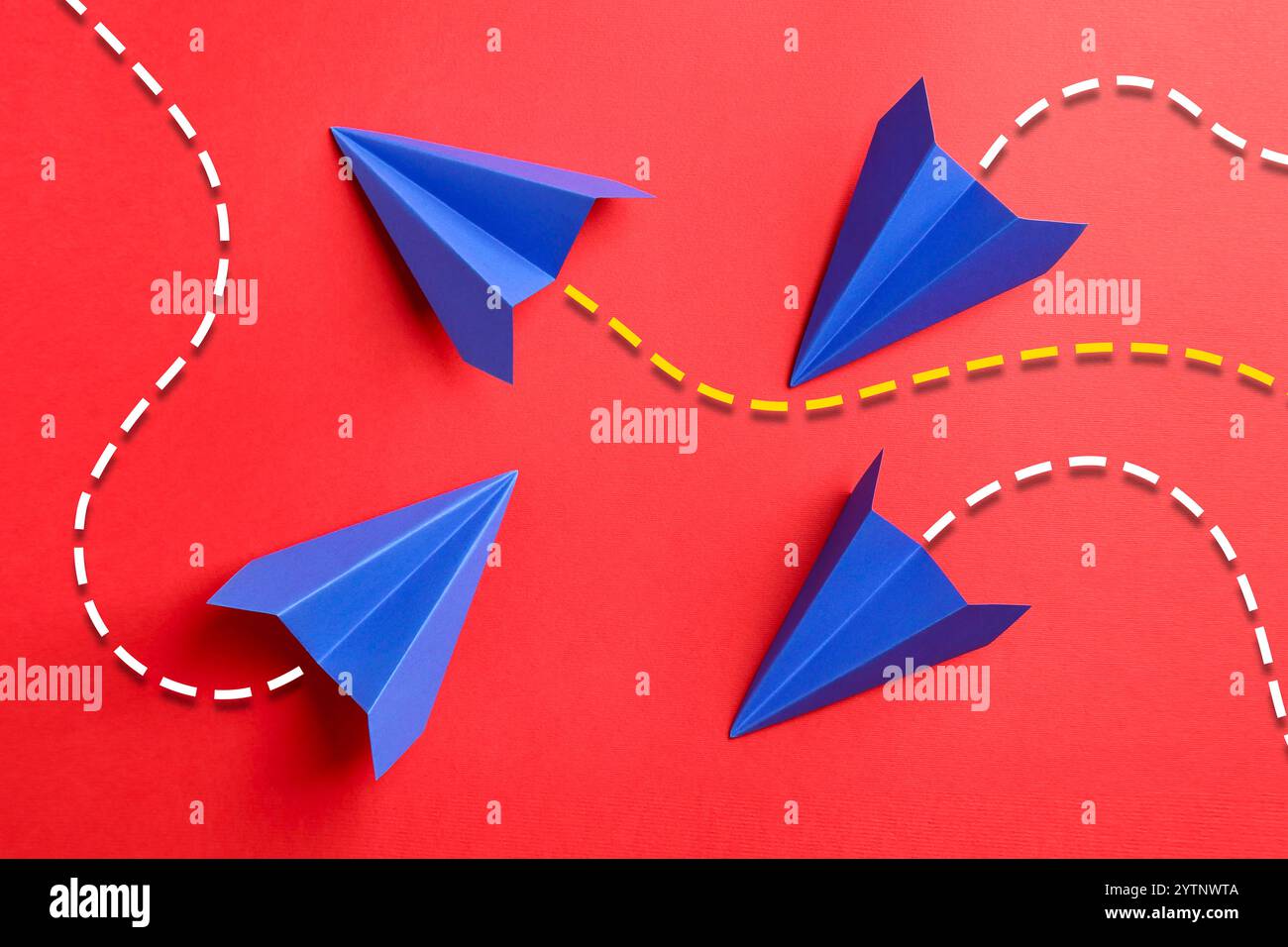 Blue paper planes with flight paths on red background. Dashed lines for ...