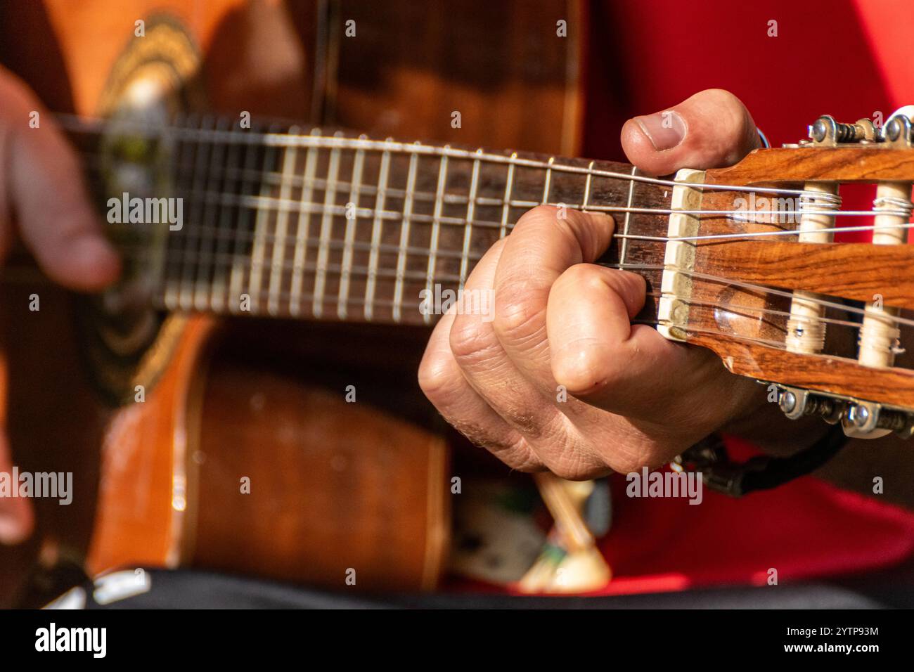 hand gripping guitar neck, creating music. man playing the Spanish ...