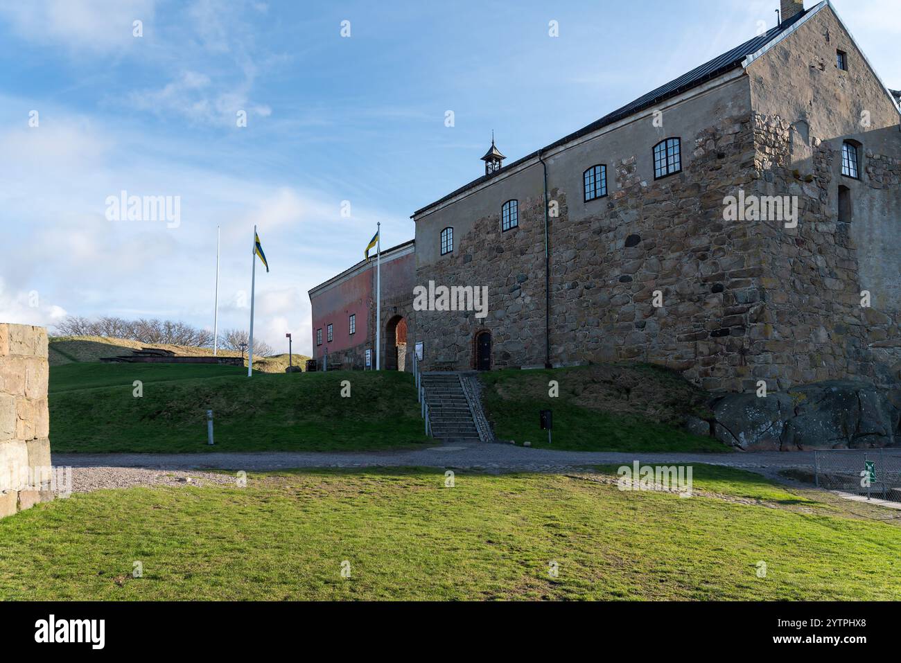 A sturdy stone fortress stands prominently atop a hill, surrounded by ...