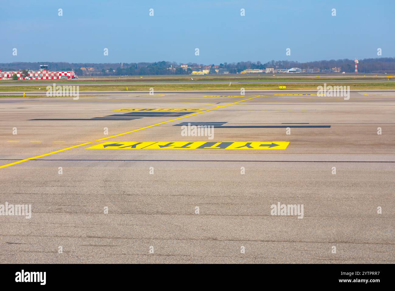 Runway with a prominent yellow lines marking the edge. Road signs for ...