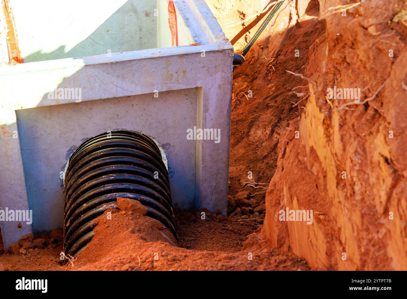 Workers are installing drainage system with black pipe laid in trench ...