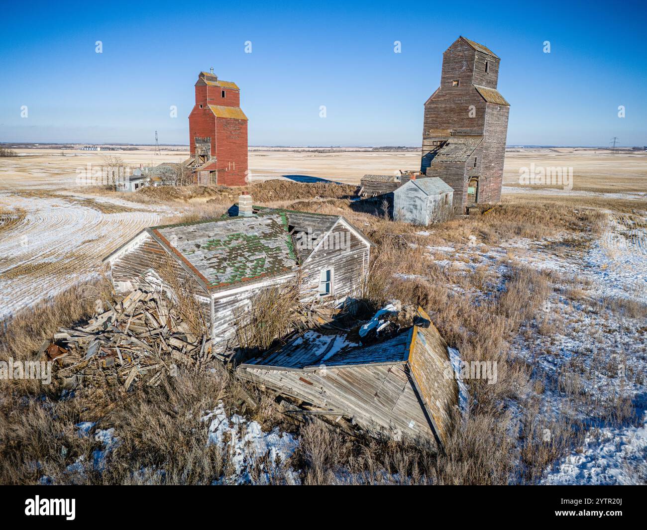 A desolate landscape with two old buildings and a large empty field ...
