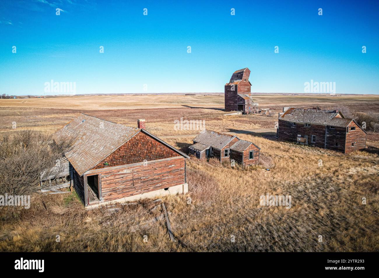 A desolate landscape with three old buildings. The buildings are in ...