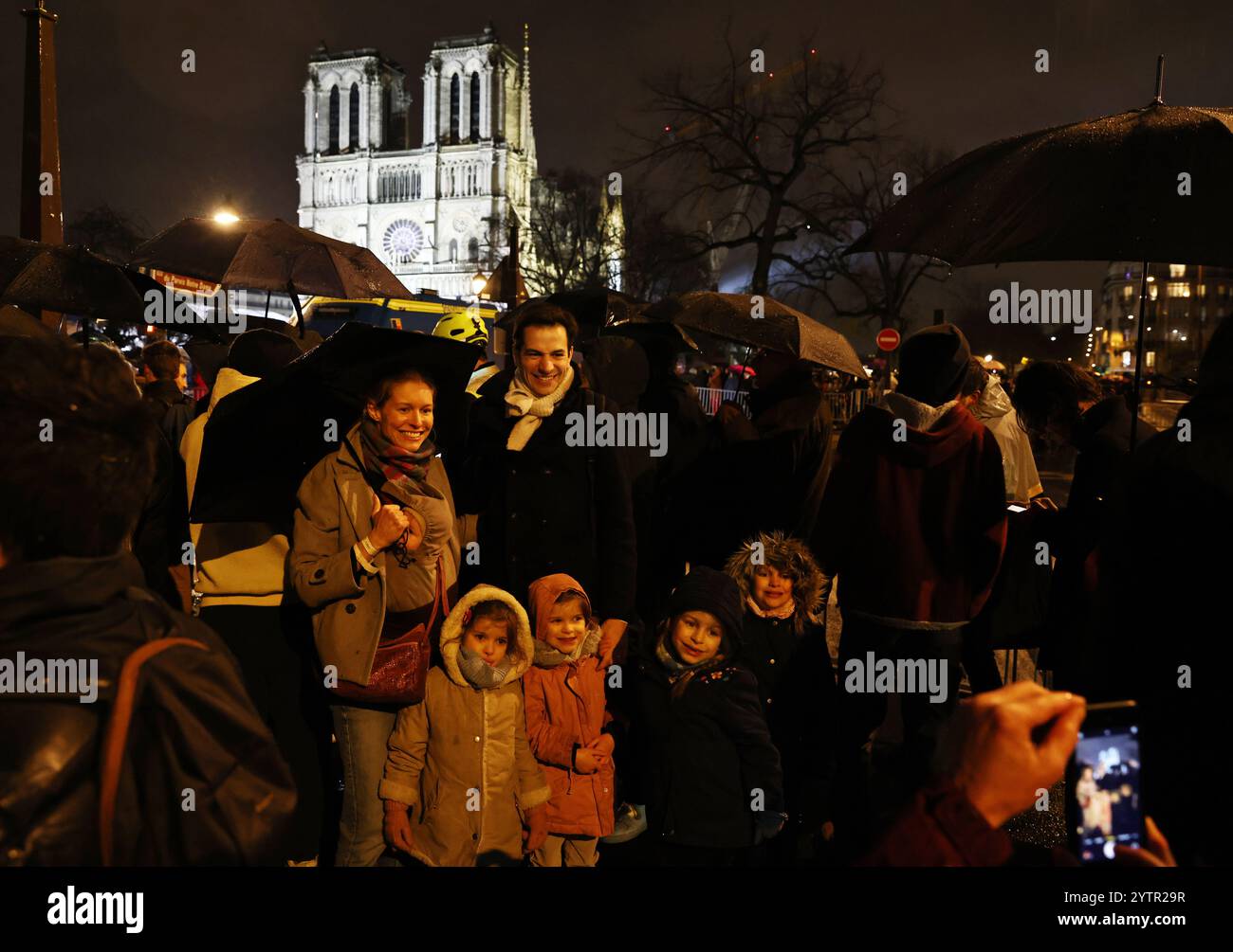 Paris, France. 7th Dec, 2024. People pose for photos outside the ...