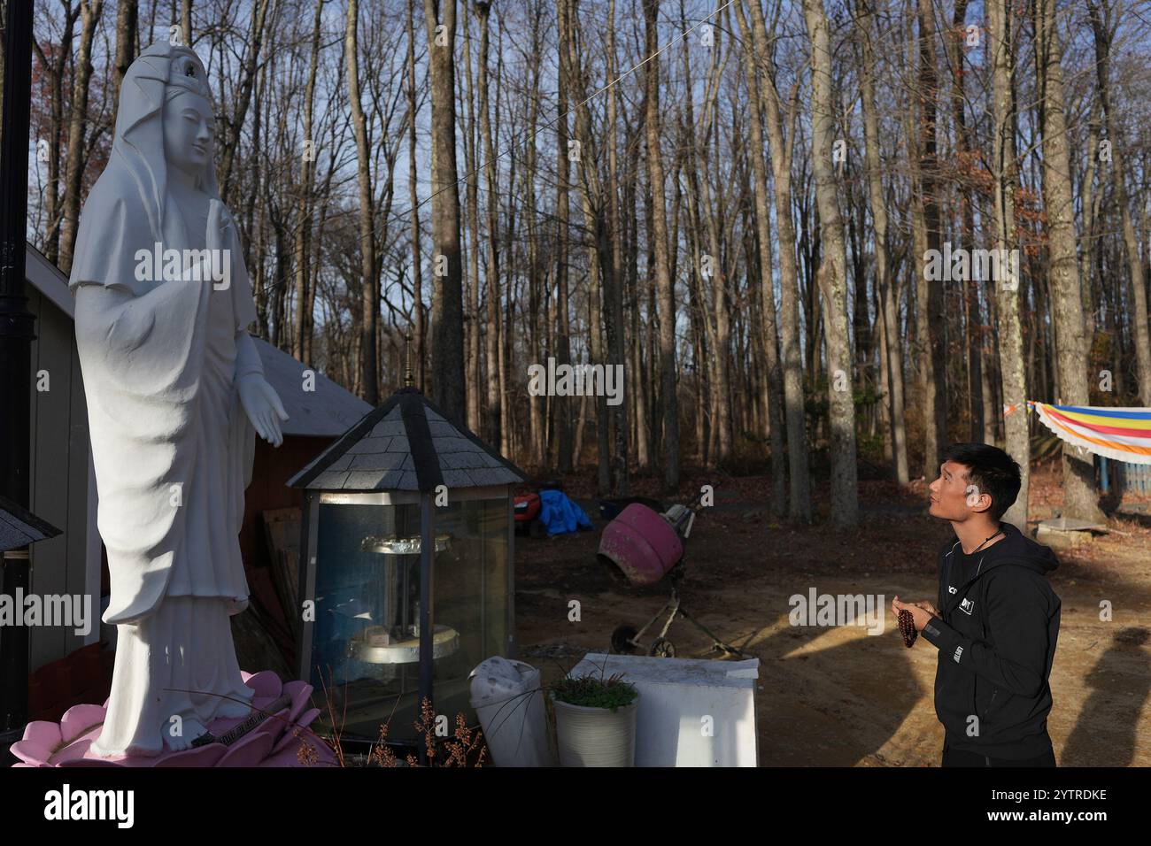 Daniel Choi stands in front of a statue of Kuan Yin, the Buddhist ...