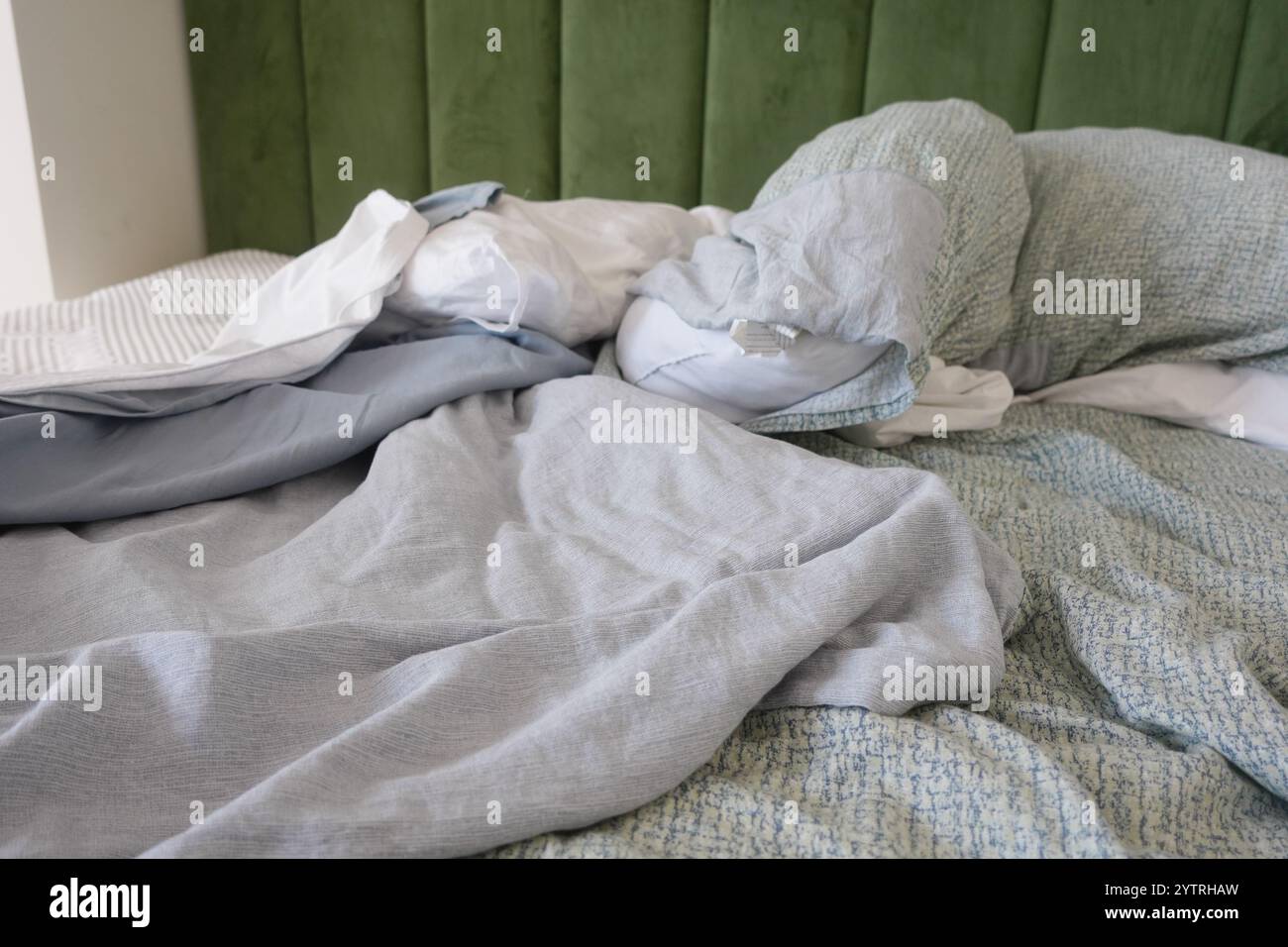 A Cozy, Disheveled Bed Featuring Crumpled Linens and Fluffy Pillows ...