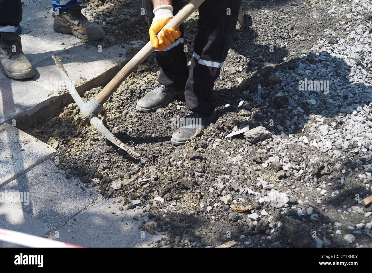 Workers are engaged in road repair with various tools and materials ...