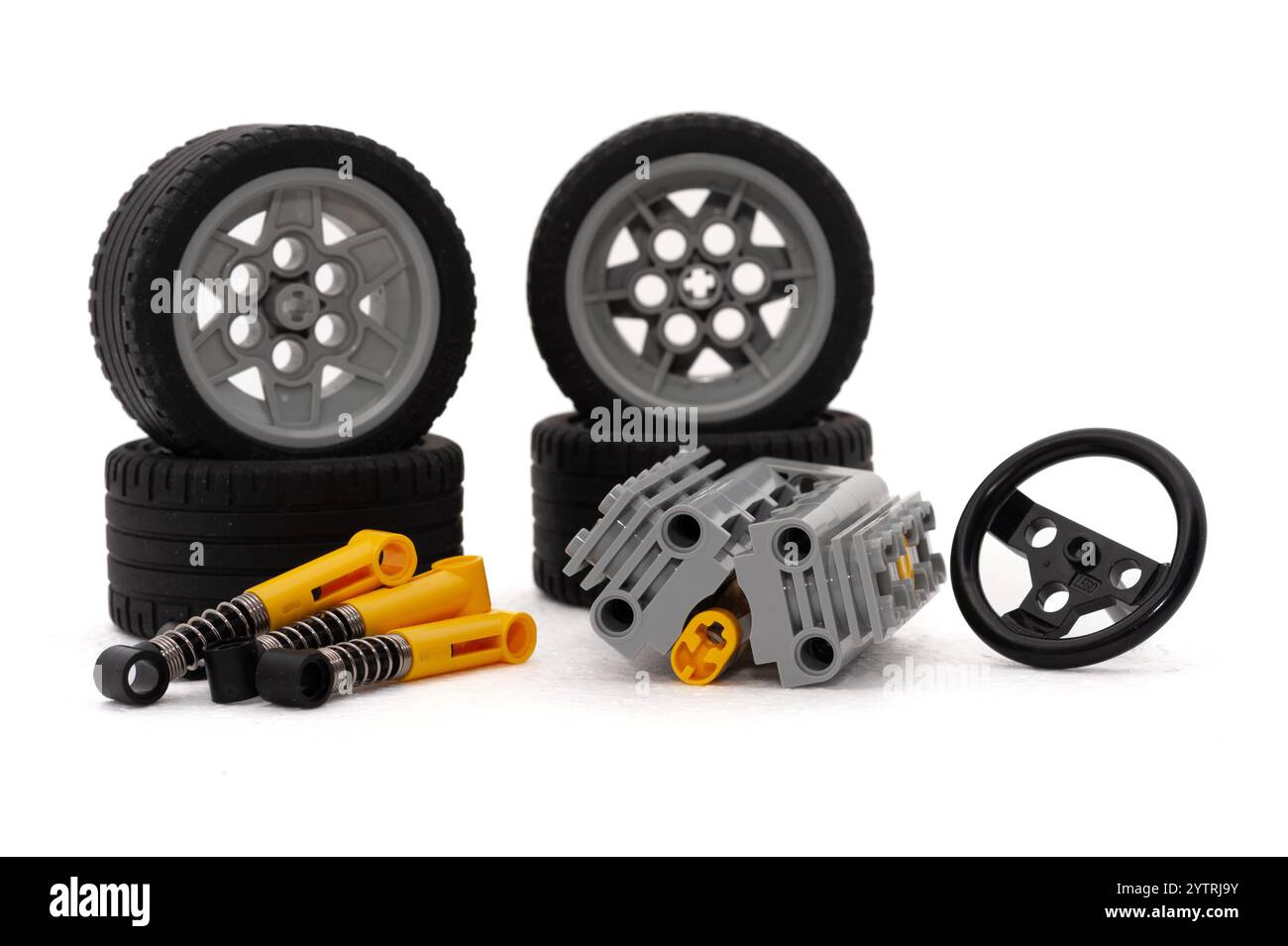 A set of toy wheels and a steering wheel. The wheels are black and ...