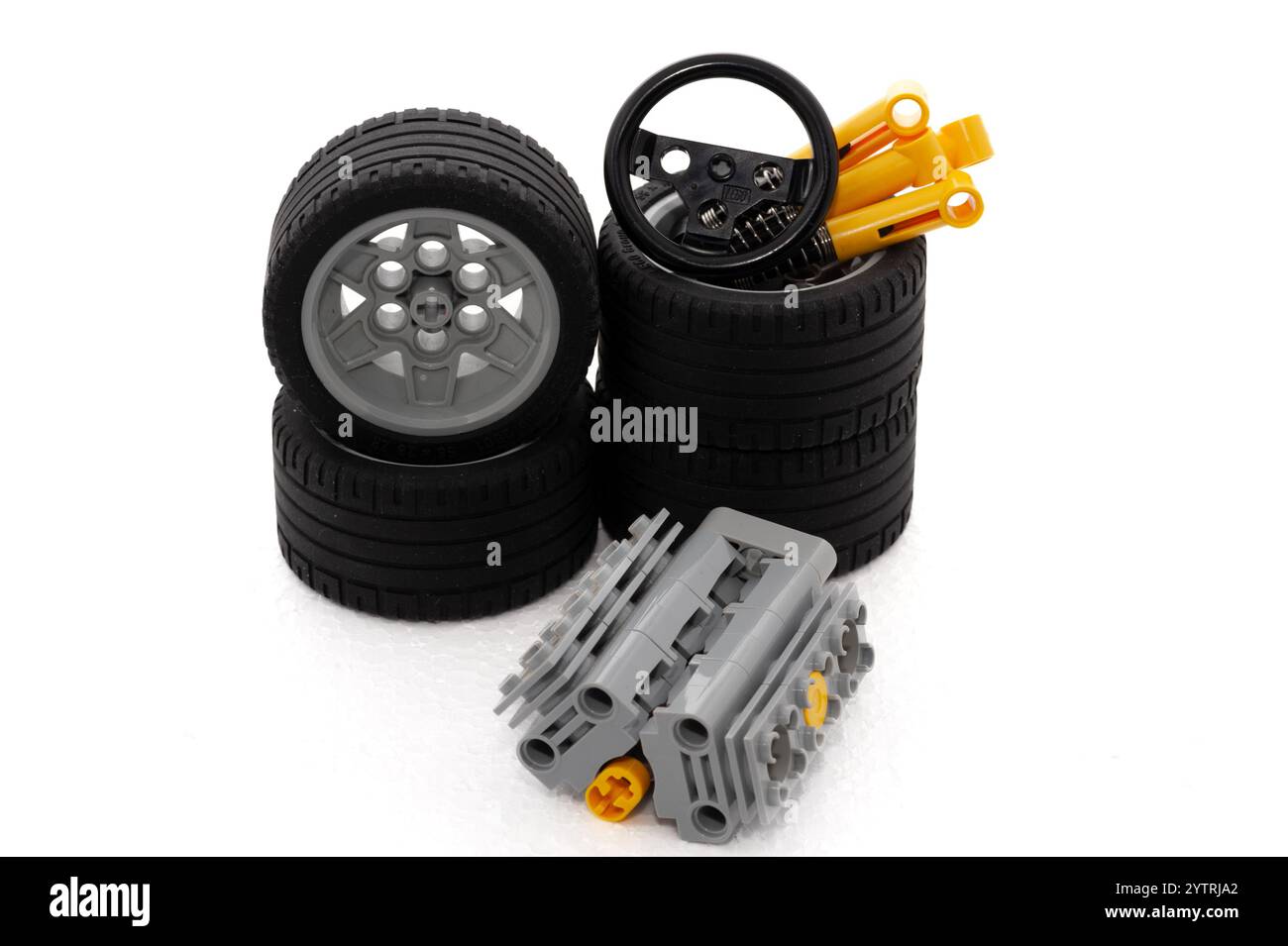 A grey toy engine with yellow circles on it. The engine is sitting on a ...