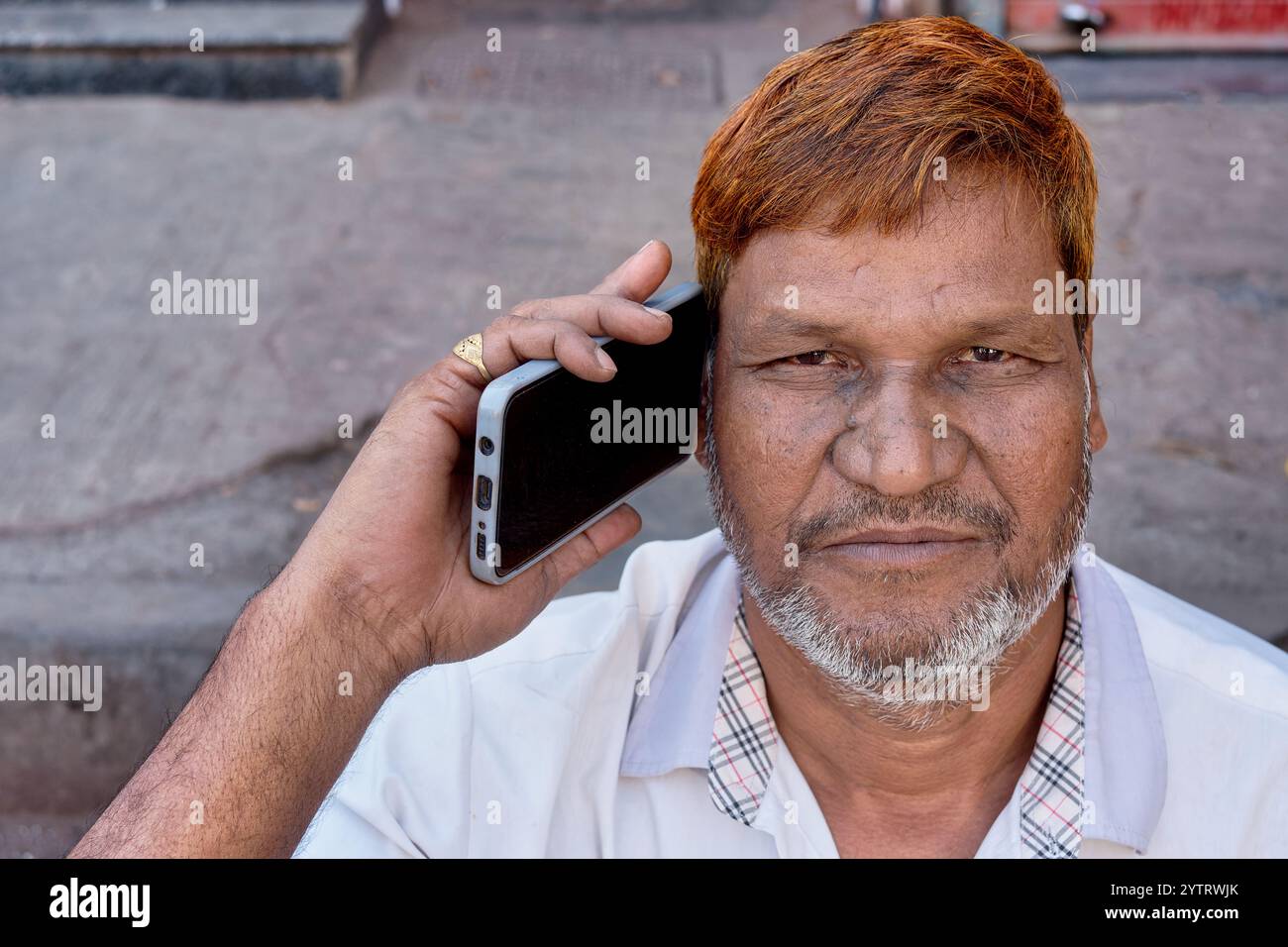 A middle-aged Muslim man with henna-dyed hair in Dharavi slum area in ...