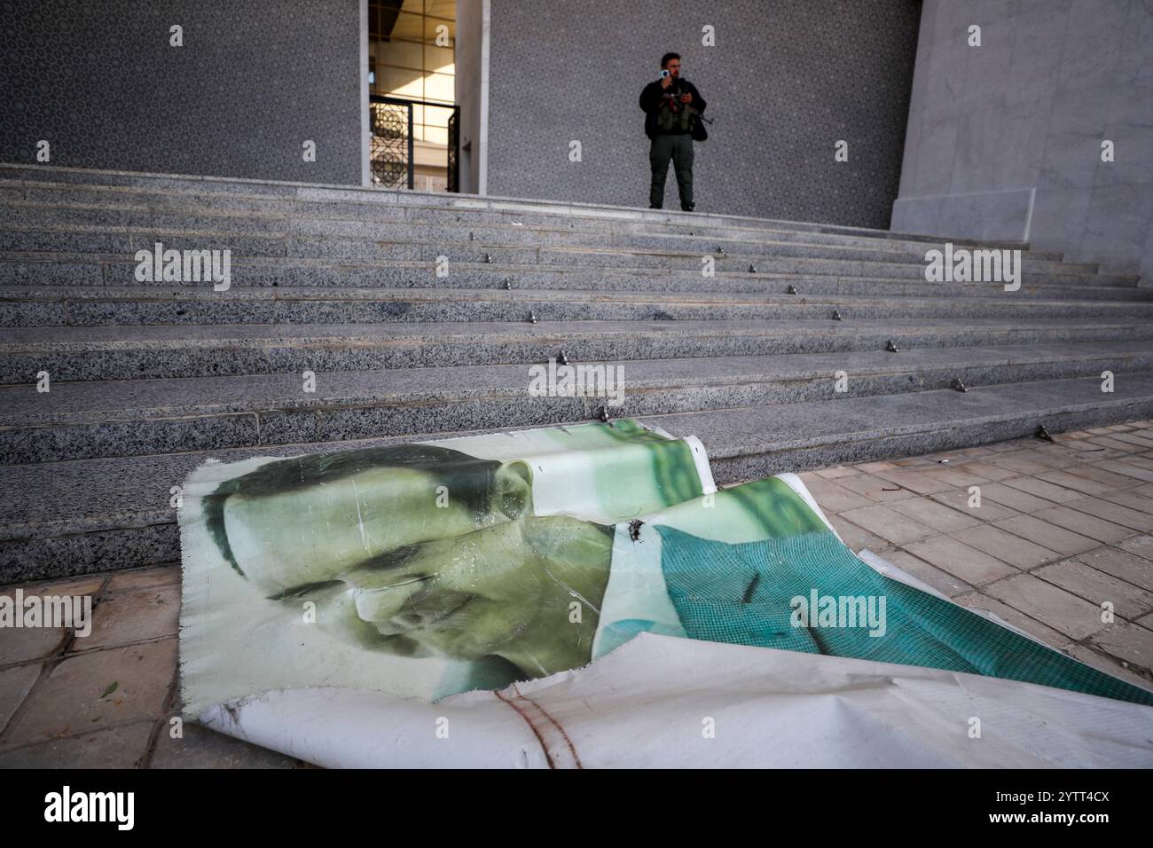 A giant picture of Syrian President Bashar Assad lies on the ground as ...