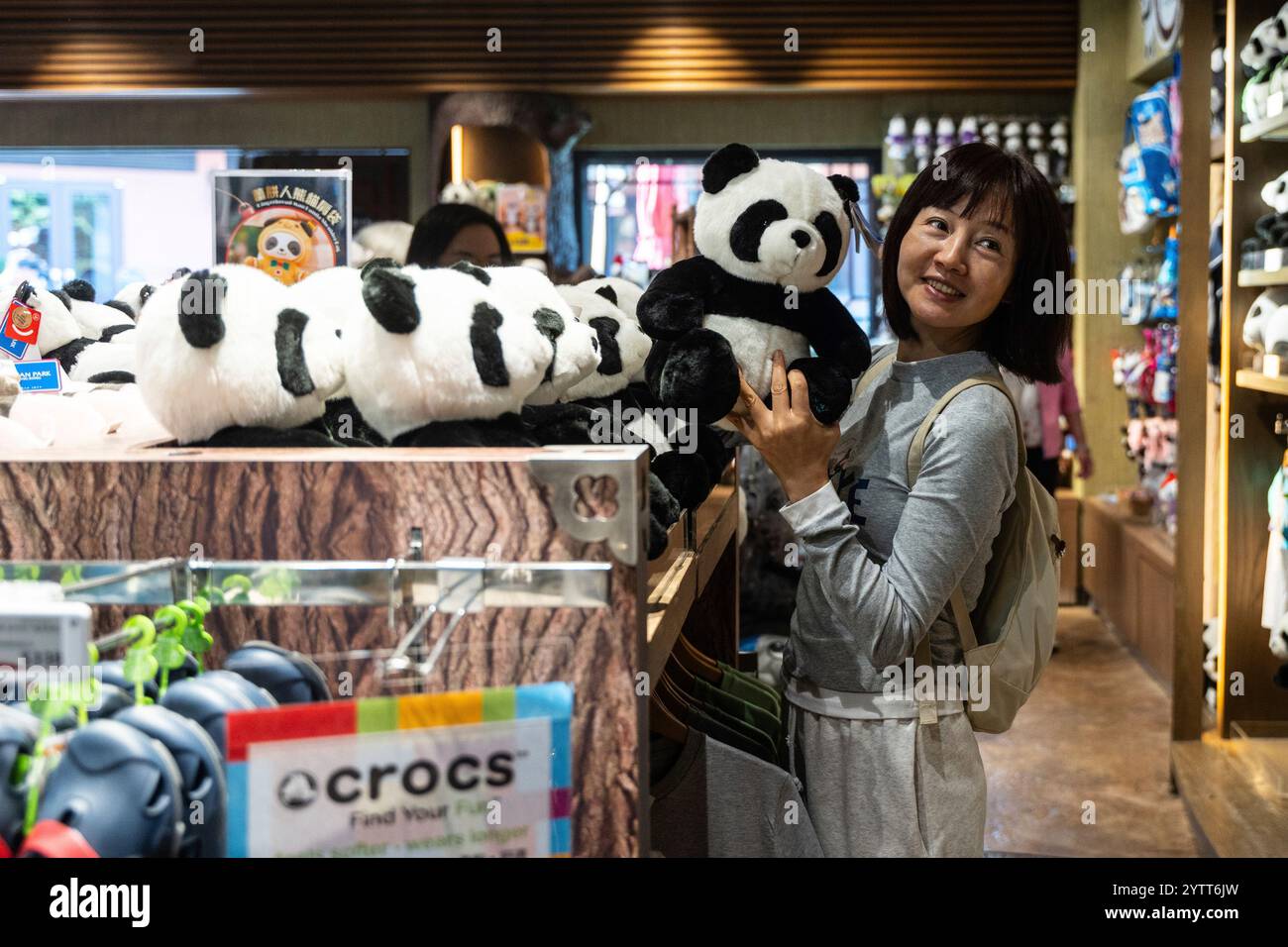 People take pictures with the panda souvenirs at a shop as the Beijing ...