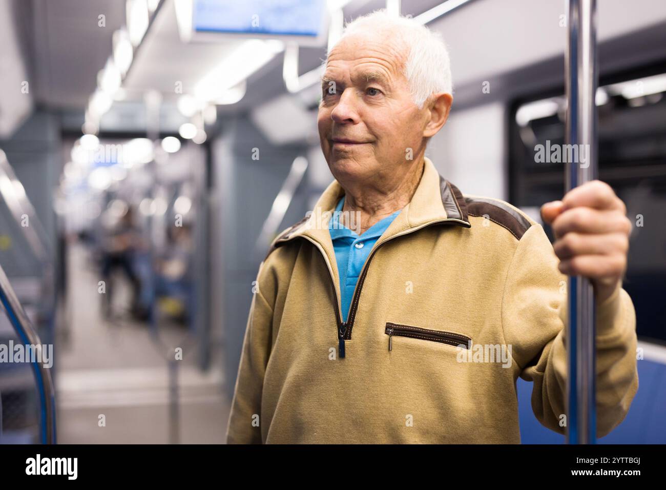 Old man standing in subway car Stock Photo - Alamy