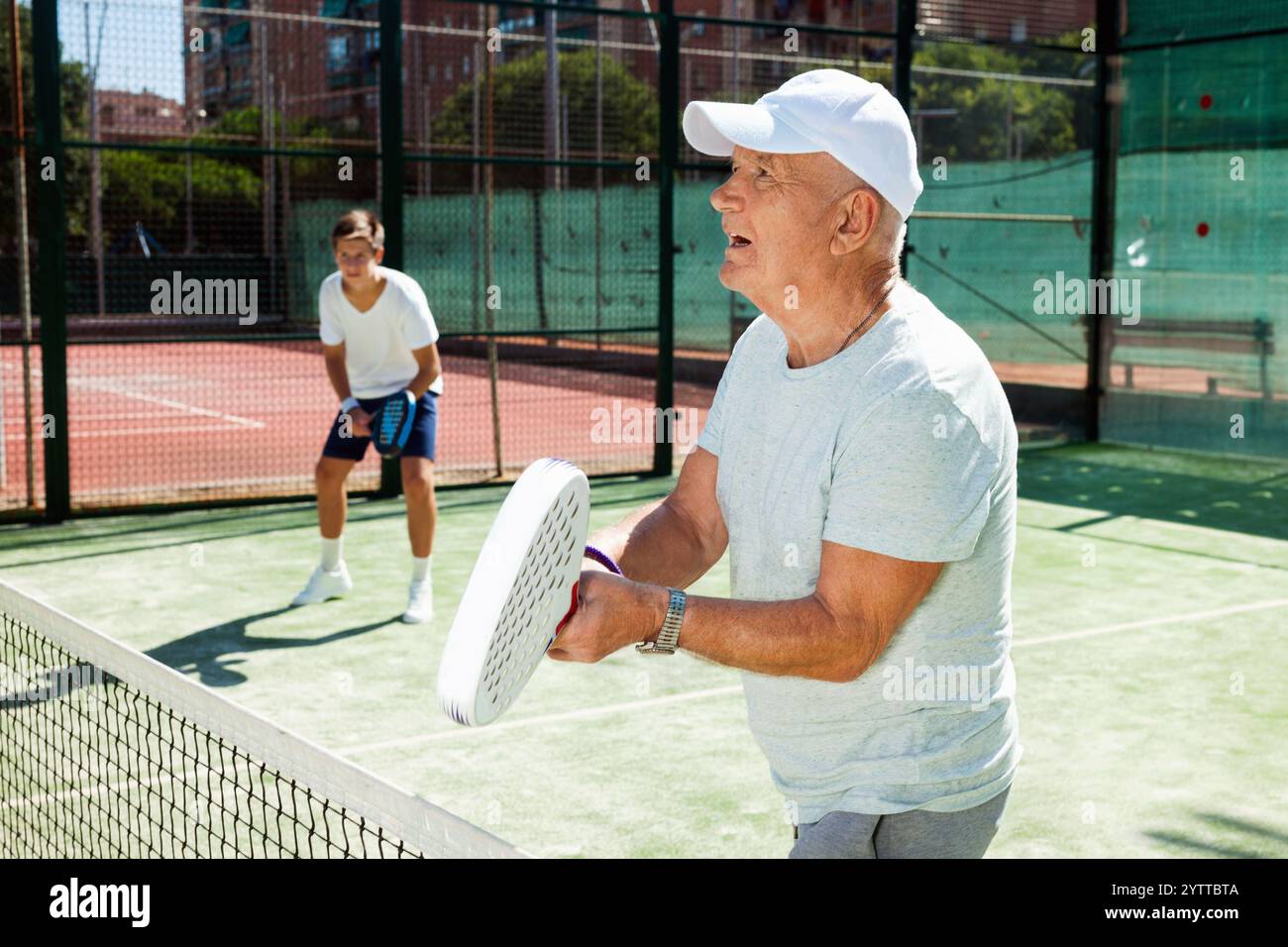 Padel players of different generations playing padel court Stock Photo ...