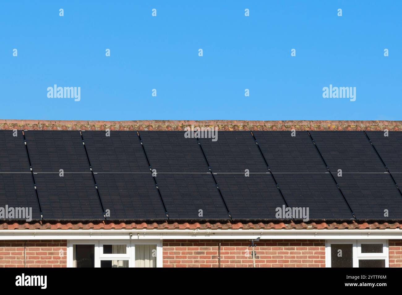 Solar panel array installed on the roof of a domestic home with a clear ...