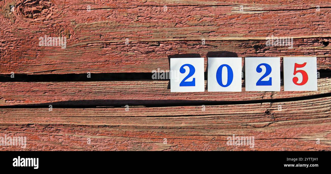 Numbers of 2025 year. Paper square numbers on the wooden fence ...