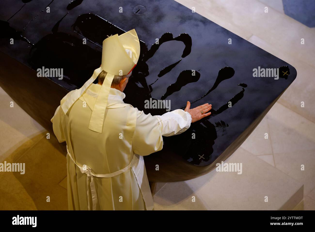 Archbishop Laurent Ulrich spreads holy oil on the altar during an ...