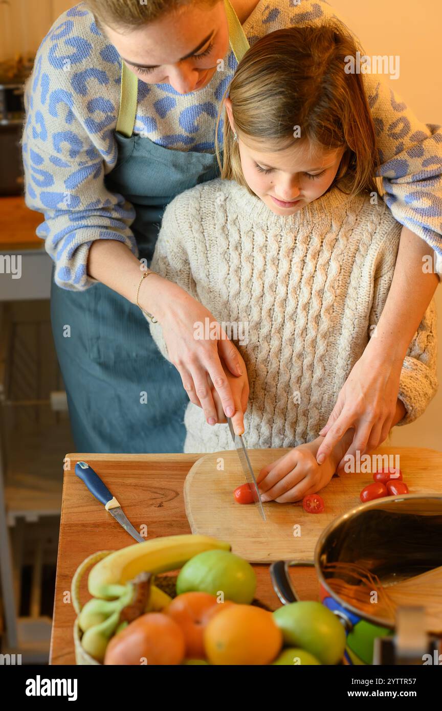 Girl is helping mother on the kitchen to prepare dinner Stock Photo - Alamy