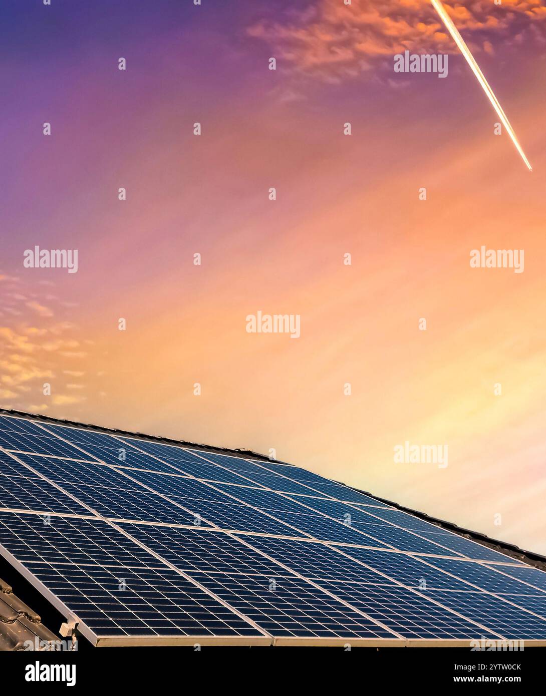 Colorful sunset on solar panels producing clean energy on a roof of a ...