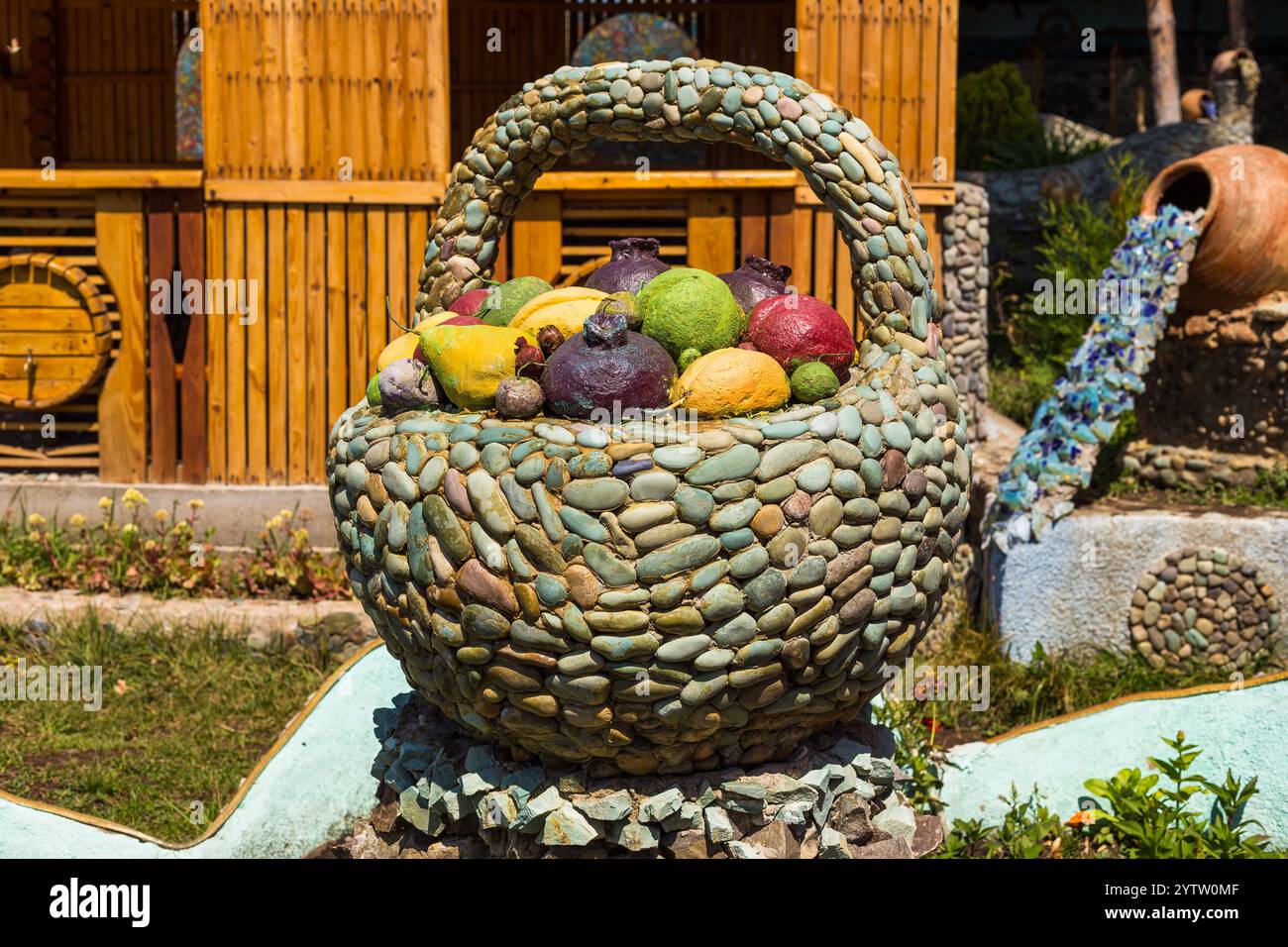 Decoration in front of a restaurant. Stone basket with colorful fruits ...
