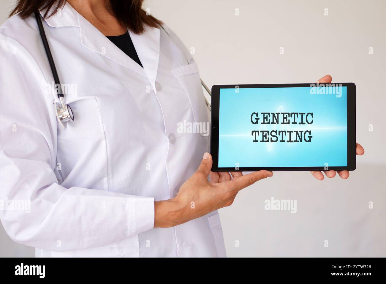 GENETIC TESTING concept. words written on a tablet held in the hands of ...