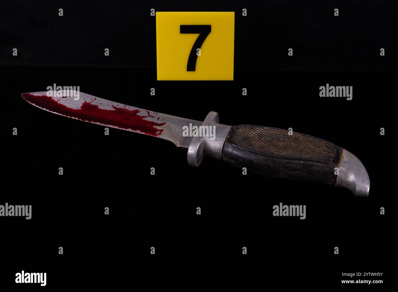 Combat knife in blood next to yellow marker with crime scene number ...