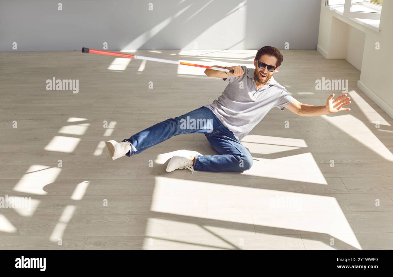 Portrait of a blind young man in black eye glasses with long stick cane ...