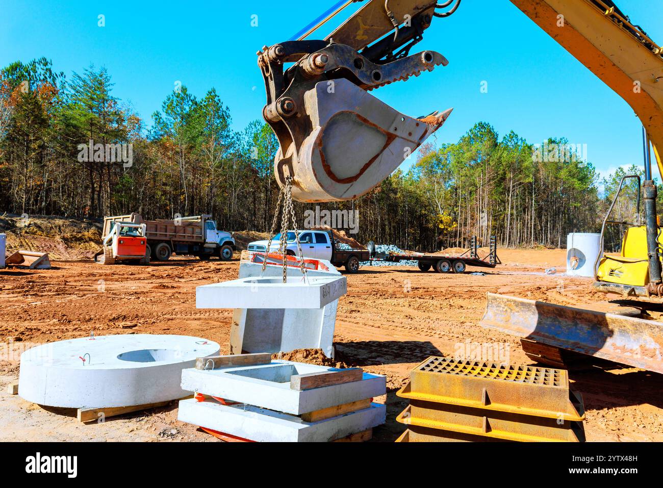 Crane lifts concrete blocks while heavy machinery vehicles are nearby ...