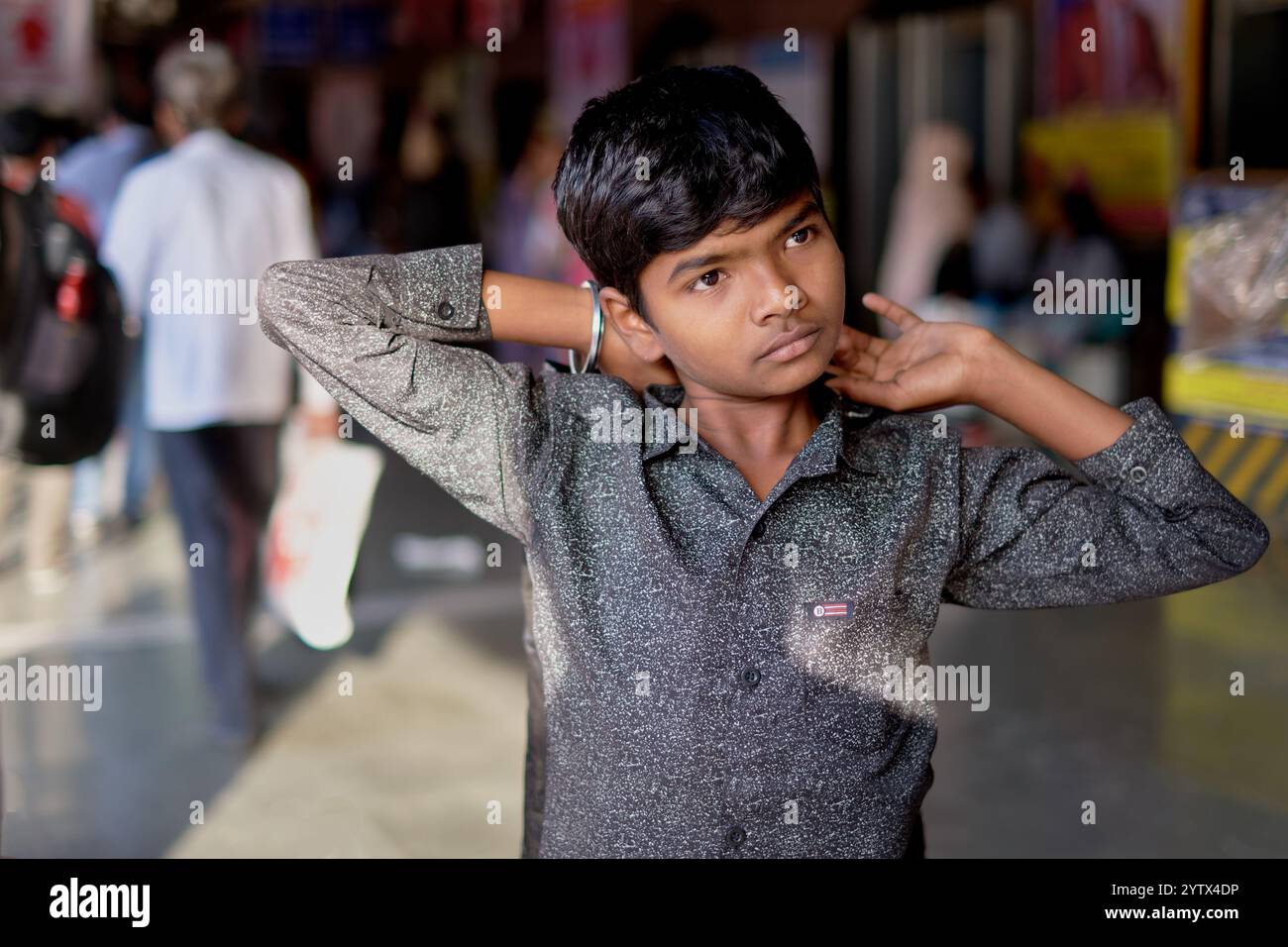 A boy on a platform at Dadar Station (rwy.) in Mumbai, India, stretches ...